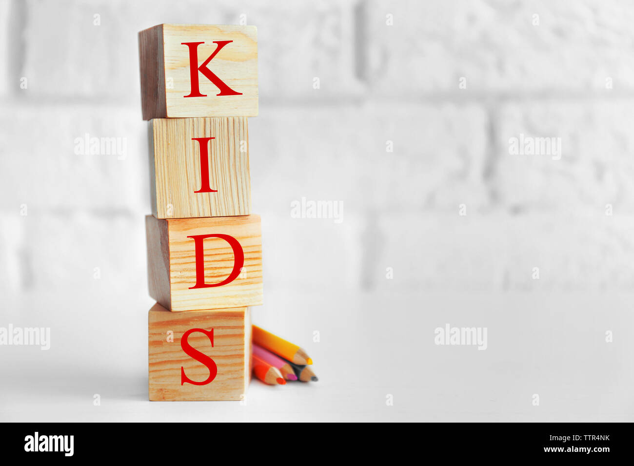 Word kids made of wooden cubes on brick wall background Stock Photo - Alamy