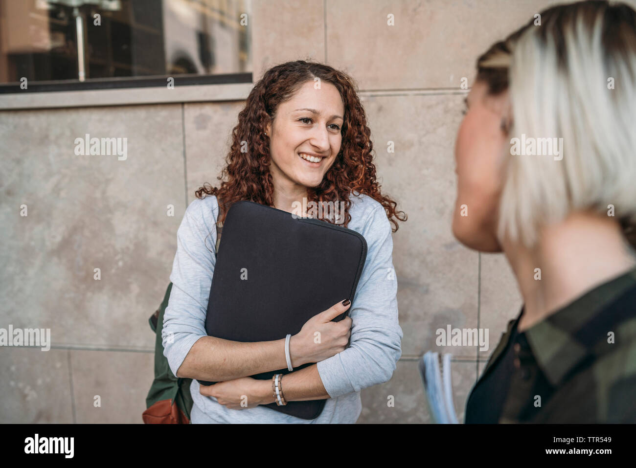 Two young students talking together in the college Stock Photo - Alamy