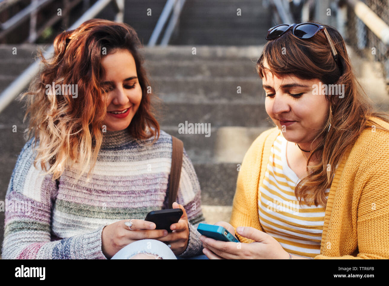 Female friends using mobile phones hi-res stock photography and images ...