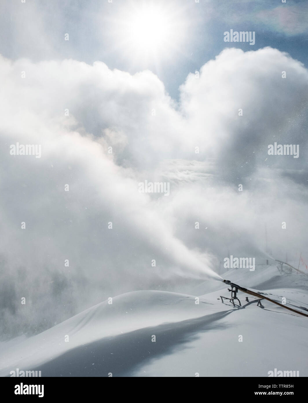 Snowblowers blowing snow on field Stock Photo - Alamy