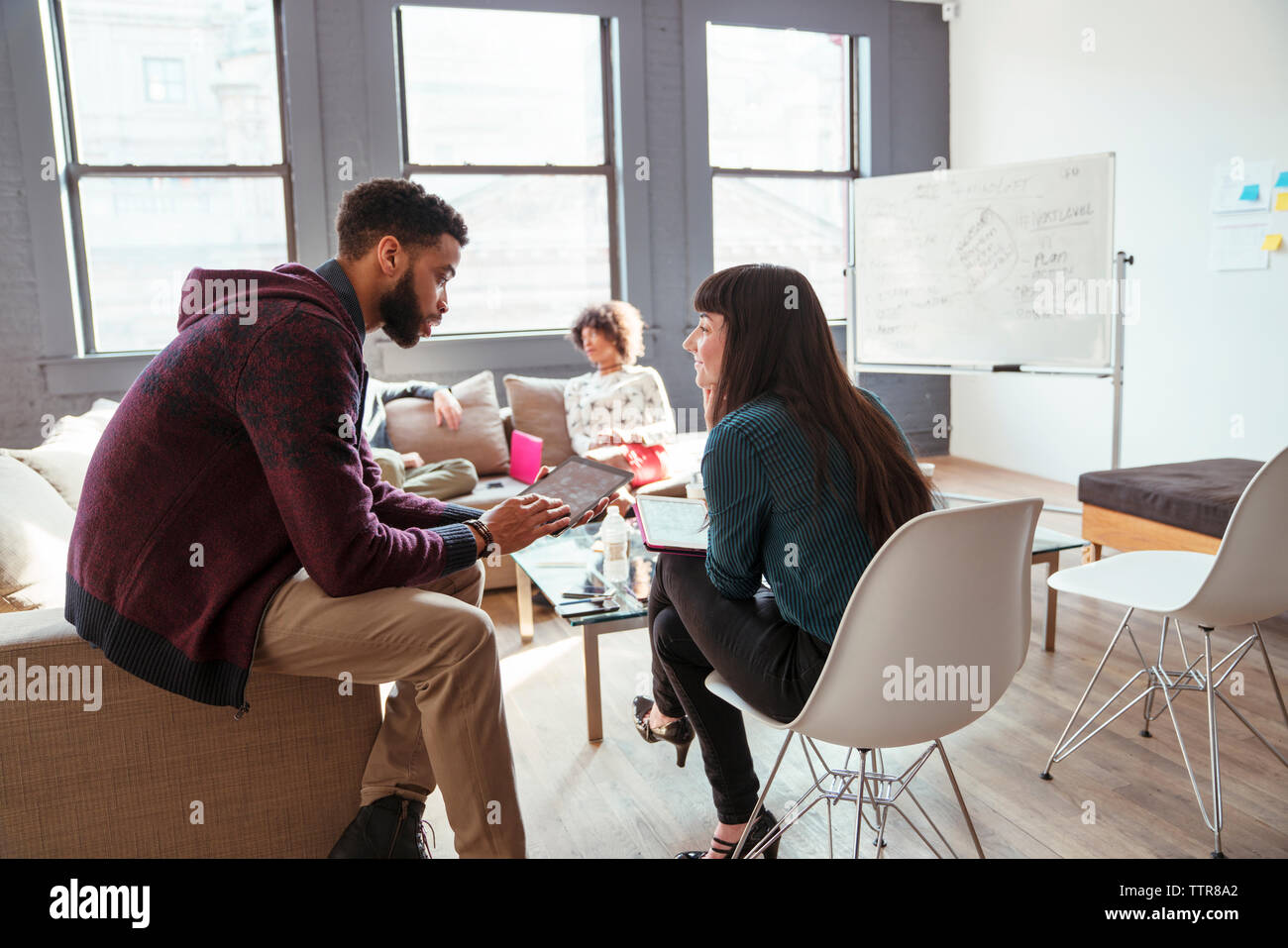 business people talking while sitting in office Stock Photo - Alamy