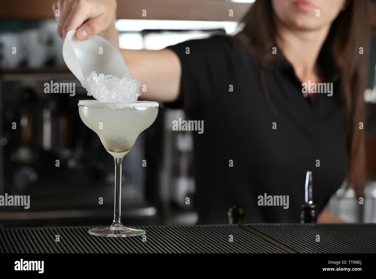 Woman hands adding ice into cocktail on bar counter Stock Photo - Alamy