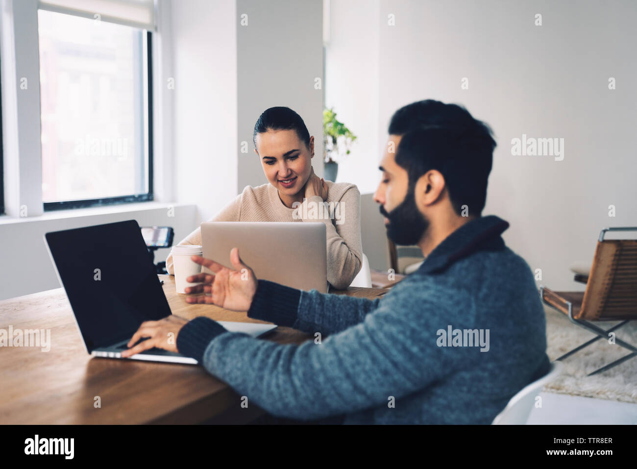 Colleagues in office using laptops hi-res stock photography and images ...