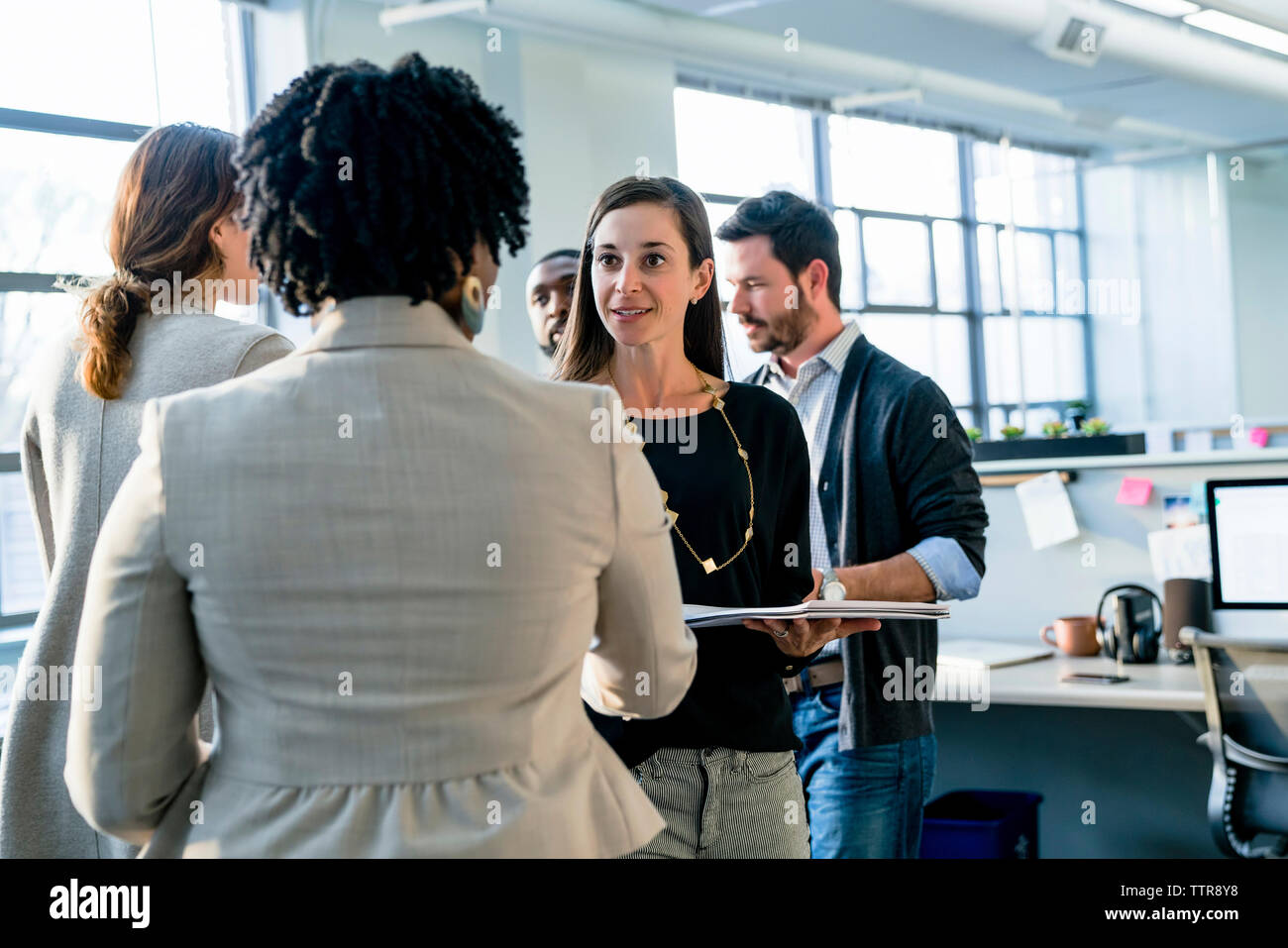 business people talking while standing in office Stock Photo - Alamy