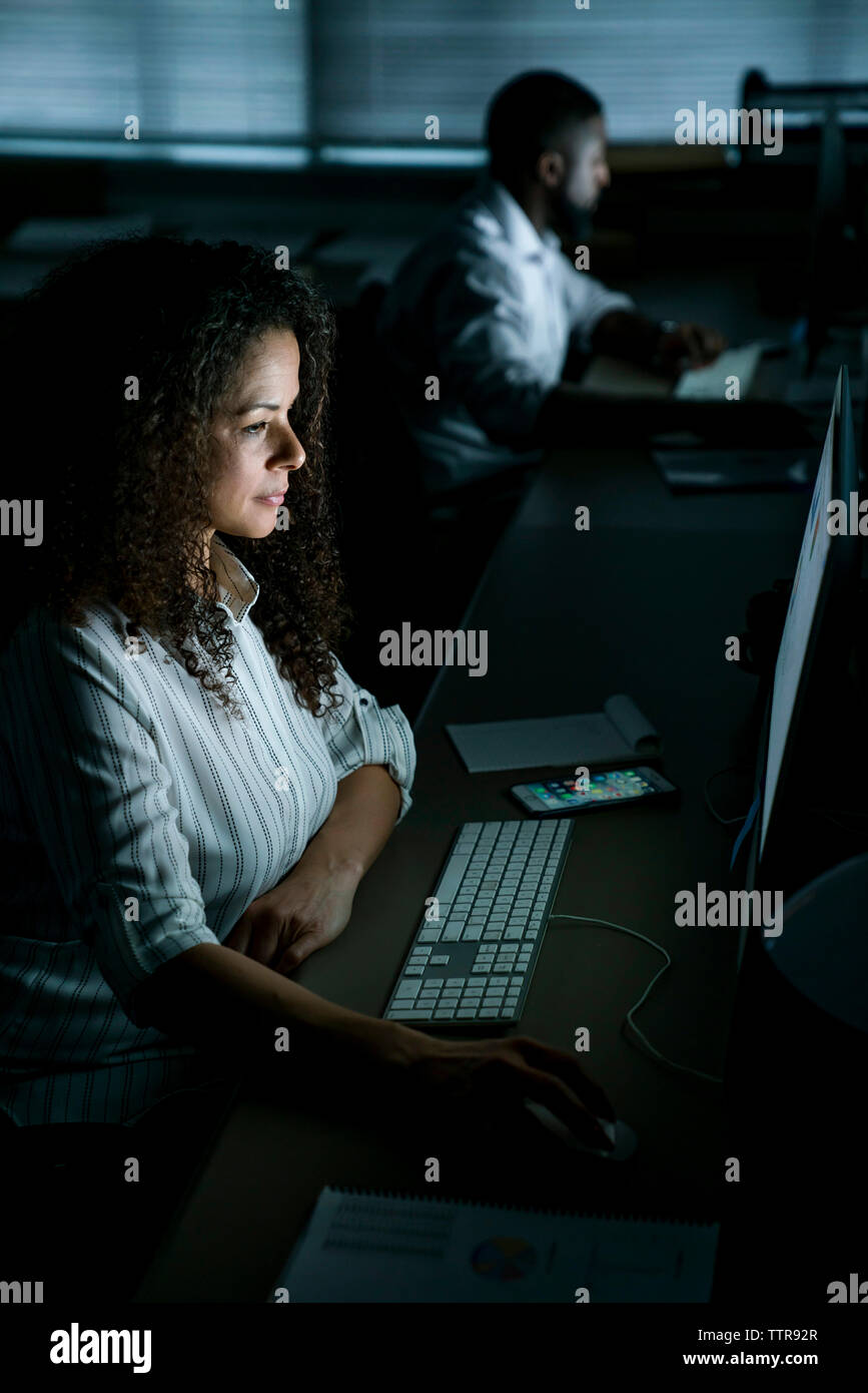 Colleagues working on desktop computers at desk in office Stock Photo ...
