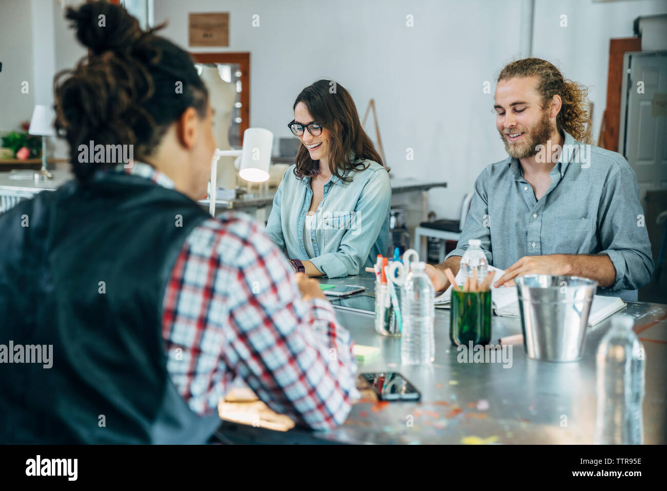 Happy business people working while sitting at conference table Stock ...
