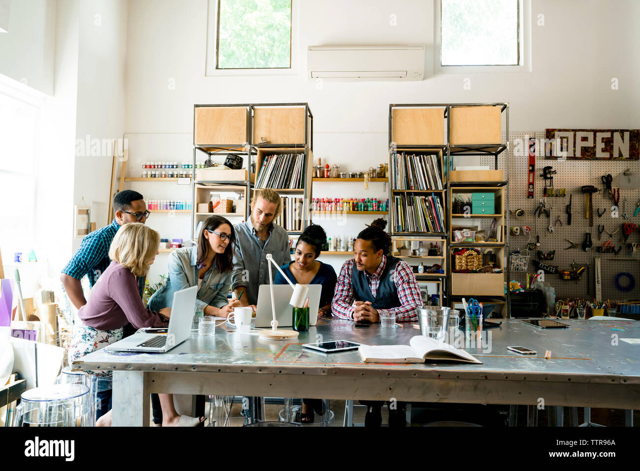 business people discussing over laptop computer at conference table ...