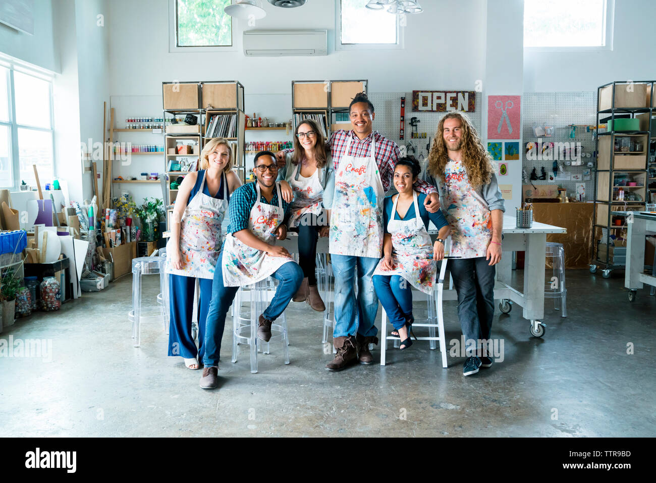 Portrait of business people wearing messy aprons in office Stock Photo ...