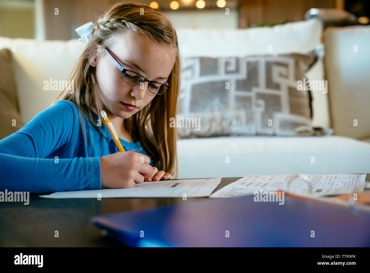 Serious girl doing homework at table Stock Photo - Alamy