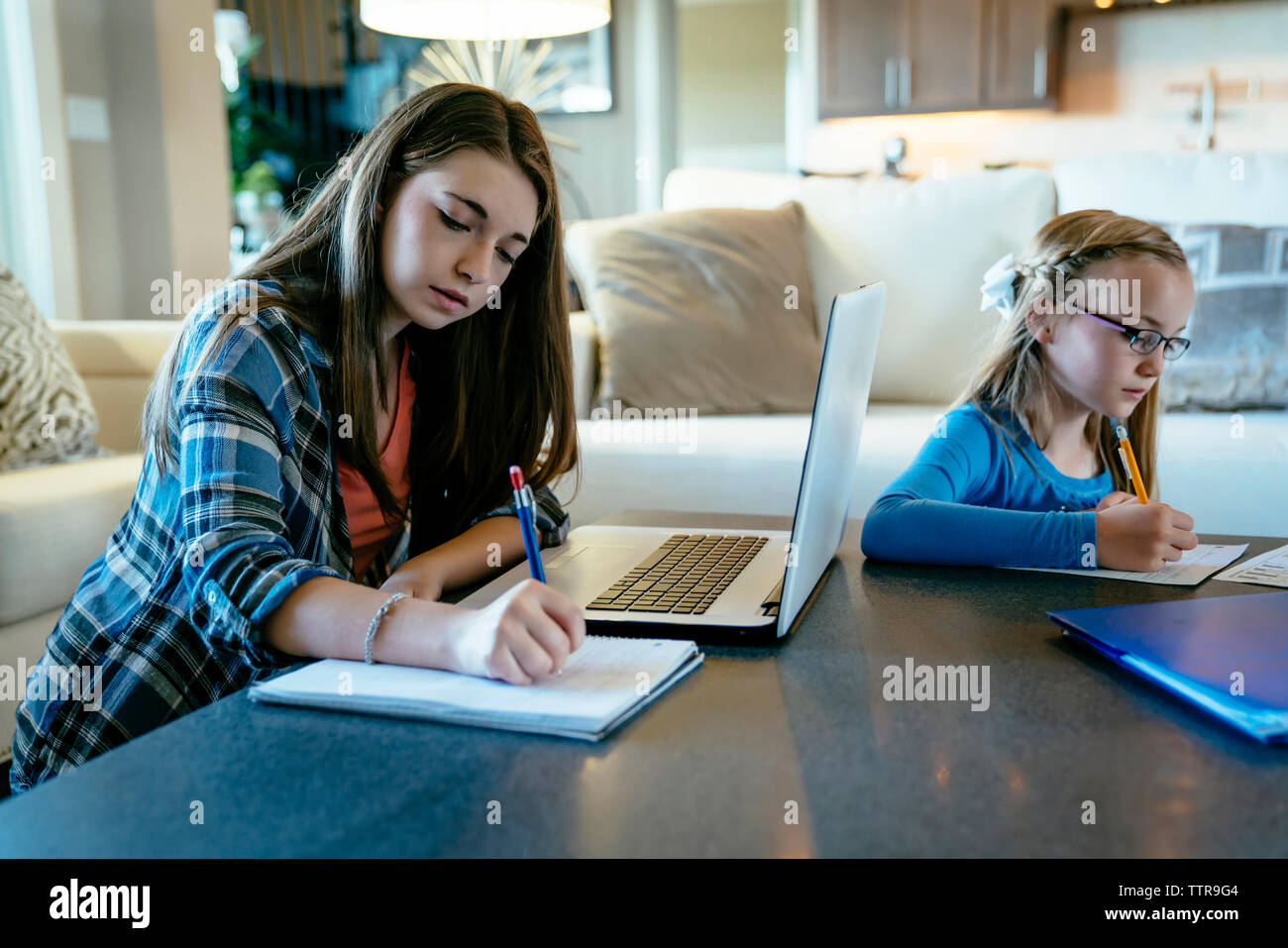 Sisters doing homework at table Stock Photo - Alamy