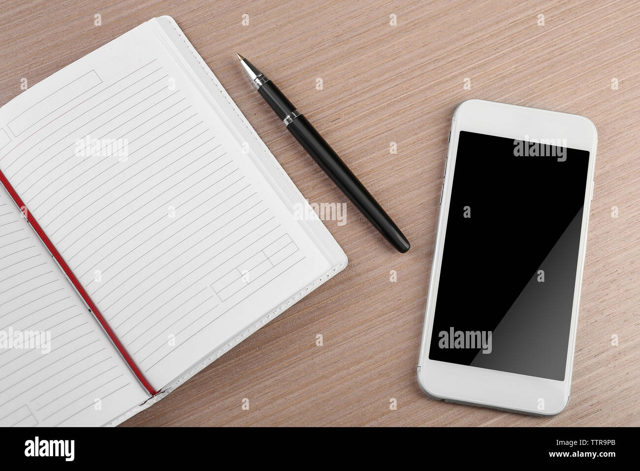 Notepad, pen and phone on wooden background Stock Photo - Alamy