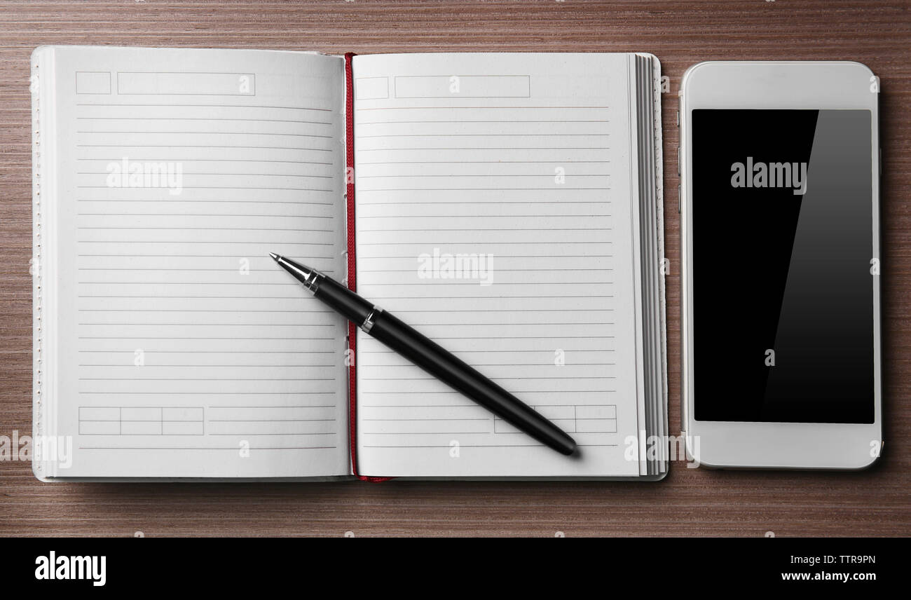 Notepad, pen and phone on wooden background Stock Photo - Alamy