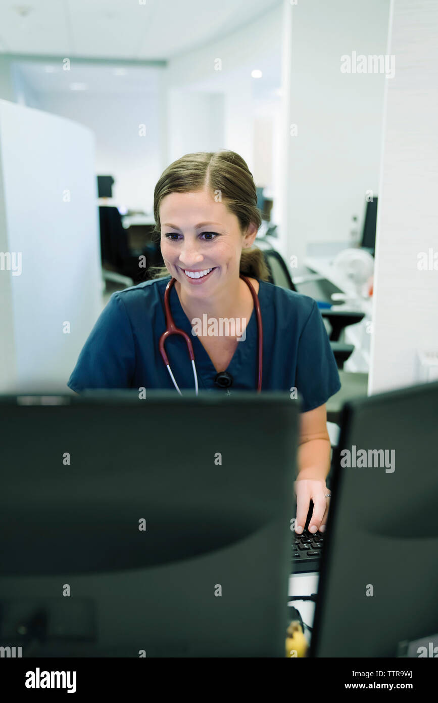 Cheerful female doctor using desktop computer in hospital Stock Photo ...