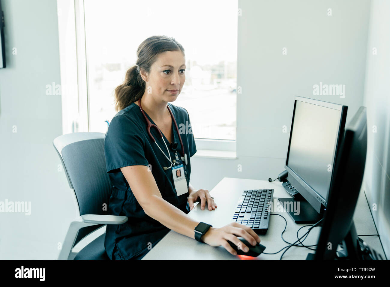 Confident female doctor using desktop computer in hospital Stock Photo ...