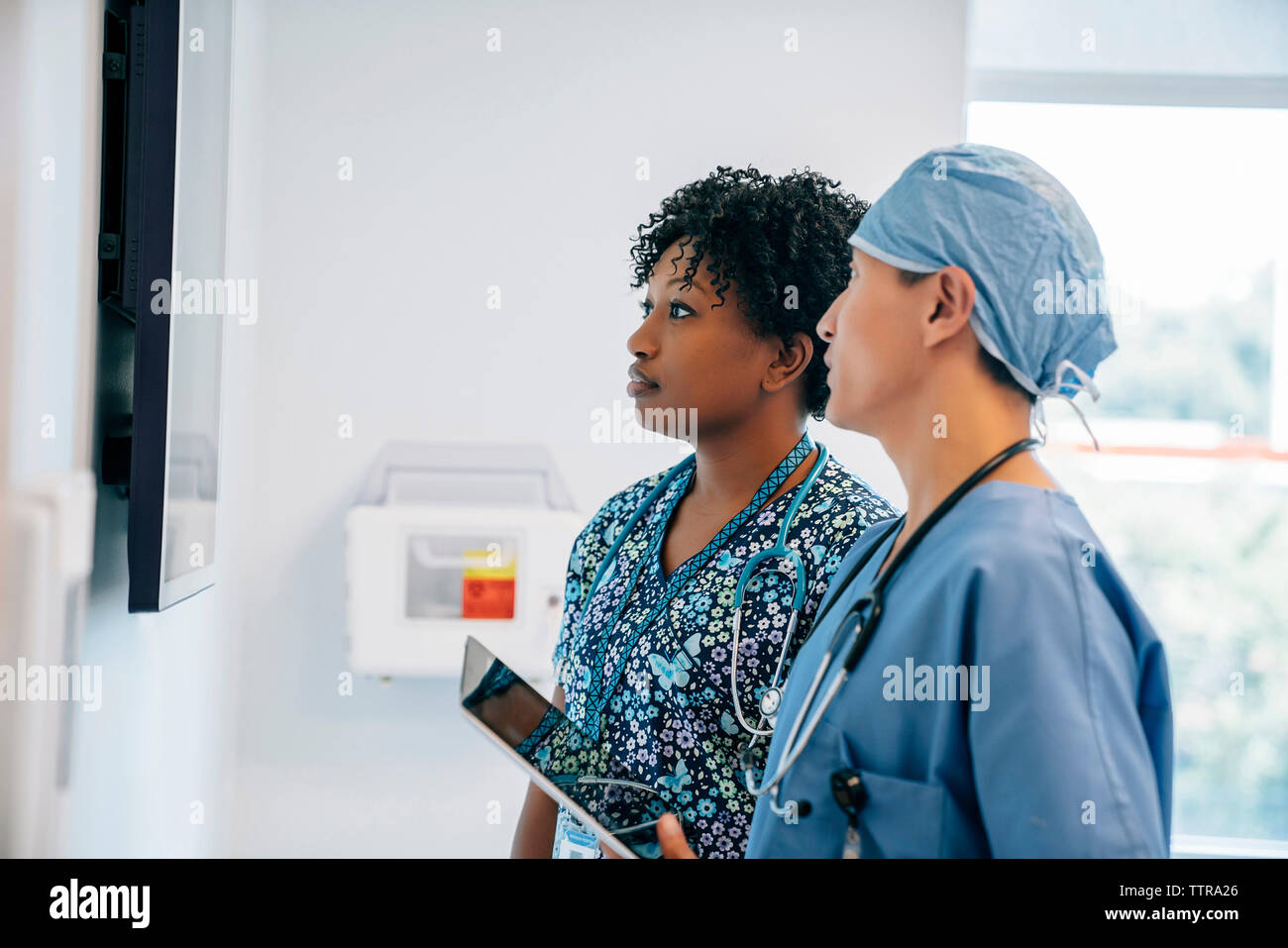 Doctors looking at flat screen while working in hospital Stock Photo ...