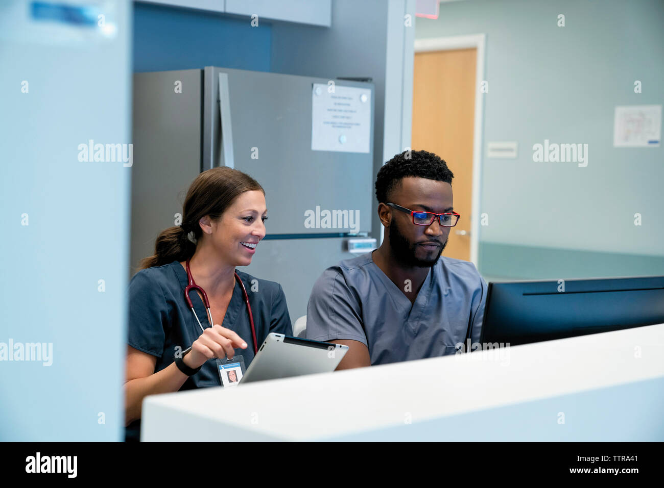 Doctors looking at desktop computer while working in hospital Stock ...