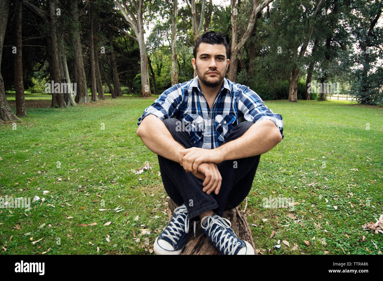 Man hugging knees looking camera hi-res stock photography and images ...