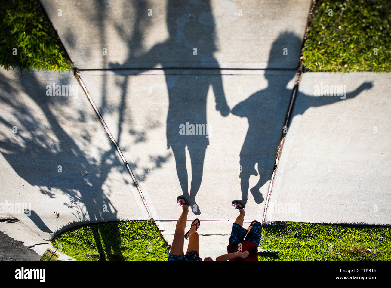Shadow of siblings walking on footpath at yard Stock Photo - Alamy