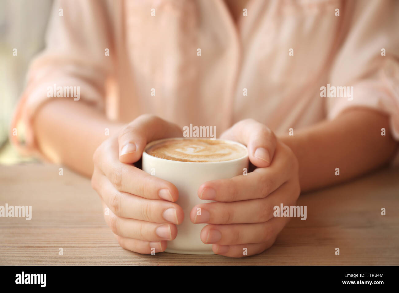 Female hands holding cup of coffee in cafe Stock Photo - Alamy