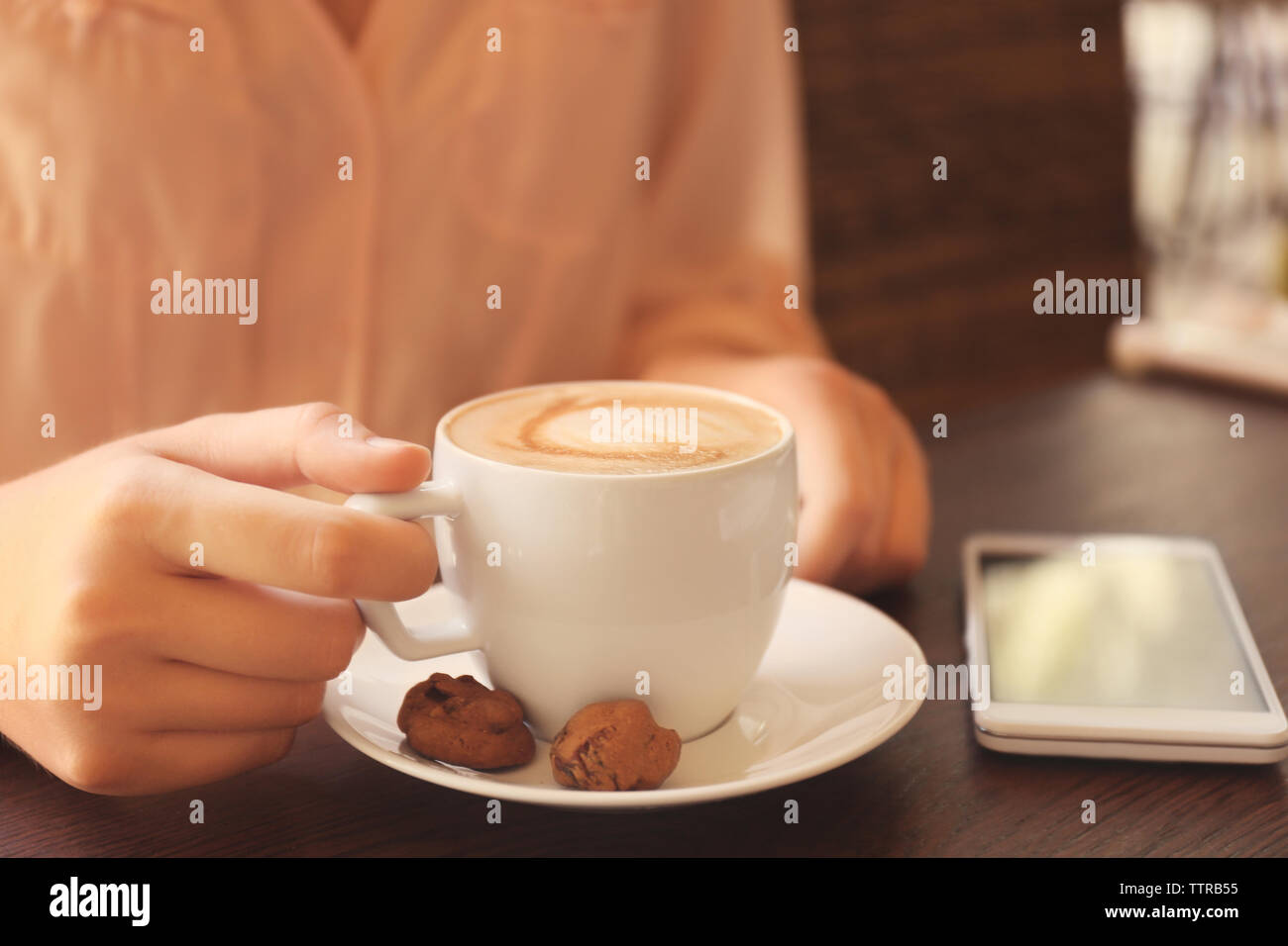 Female hand holding cup of coffee in cafe Stock Photo - Alamy