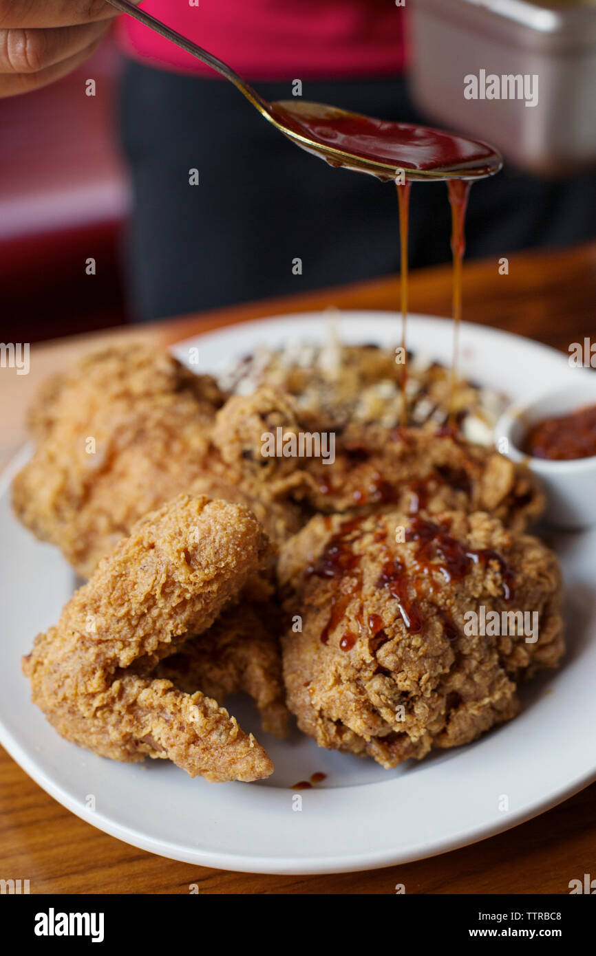 Sauce being poured on grilled chicken at table Stock Photo - Alamy