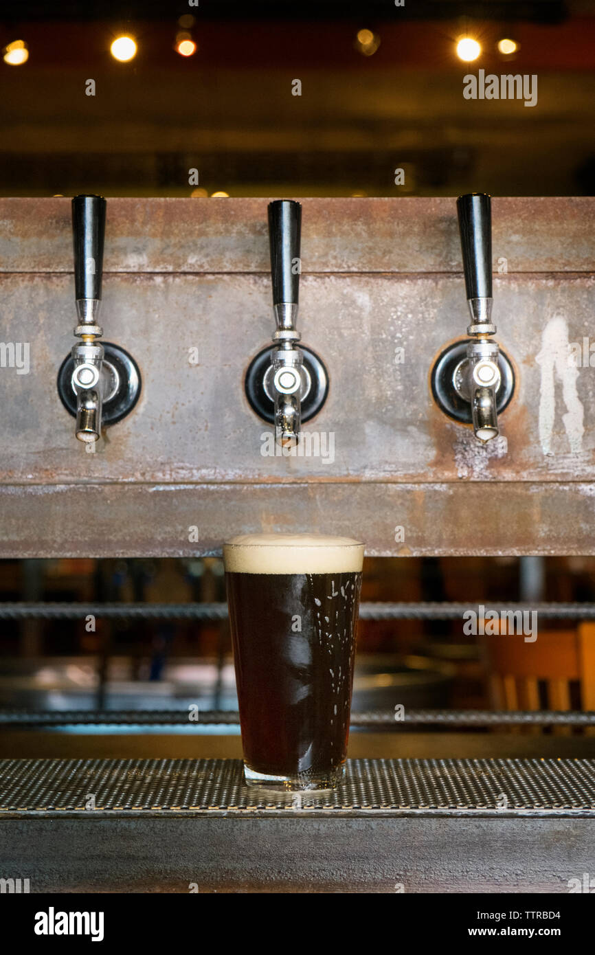 Beer glass under taps Stock Photo - Alamy