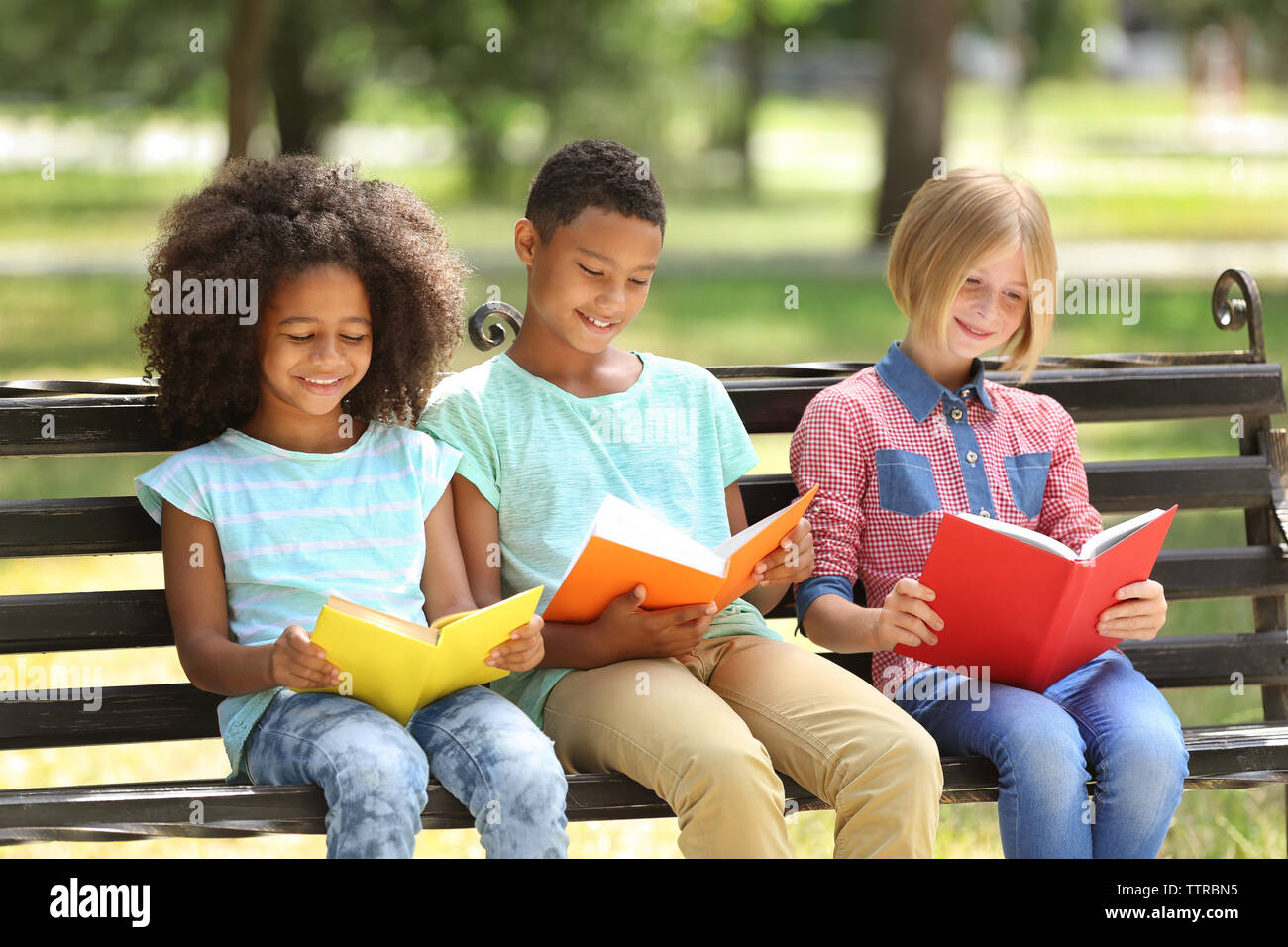 Cute kids reading books on bench Stock Photo - Alamy