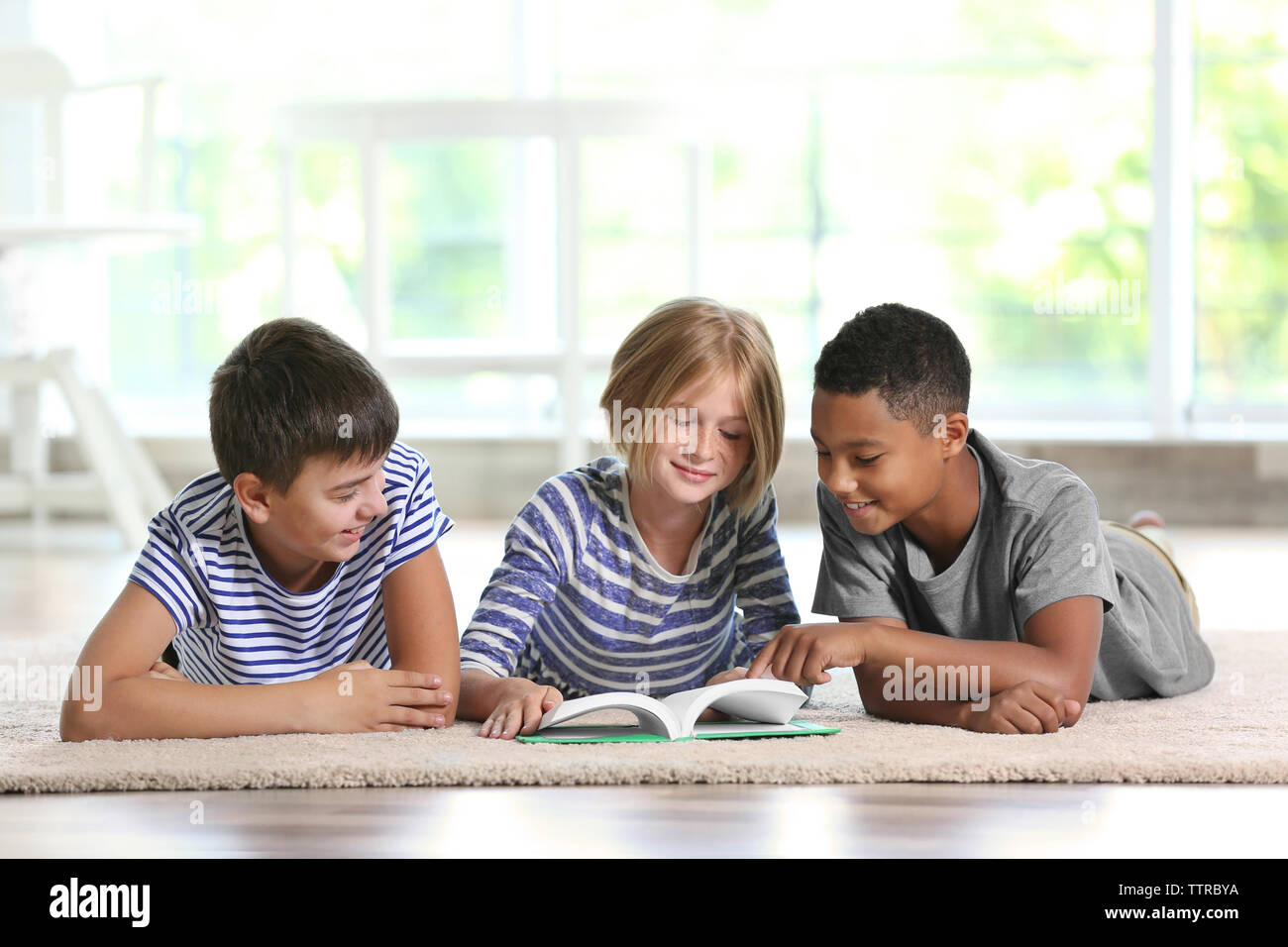 Cute kids reading book at home Stock Photo - Alamy