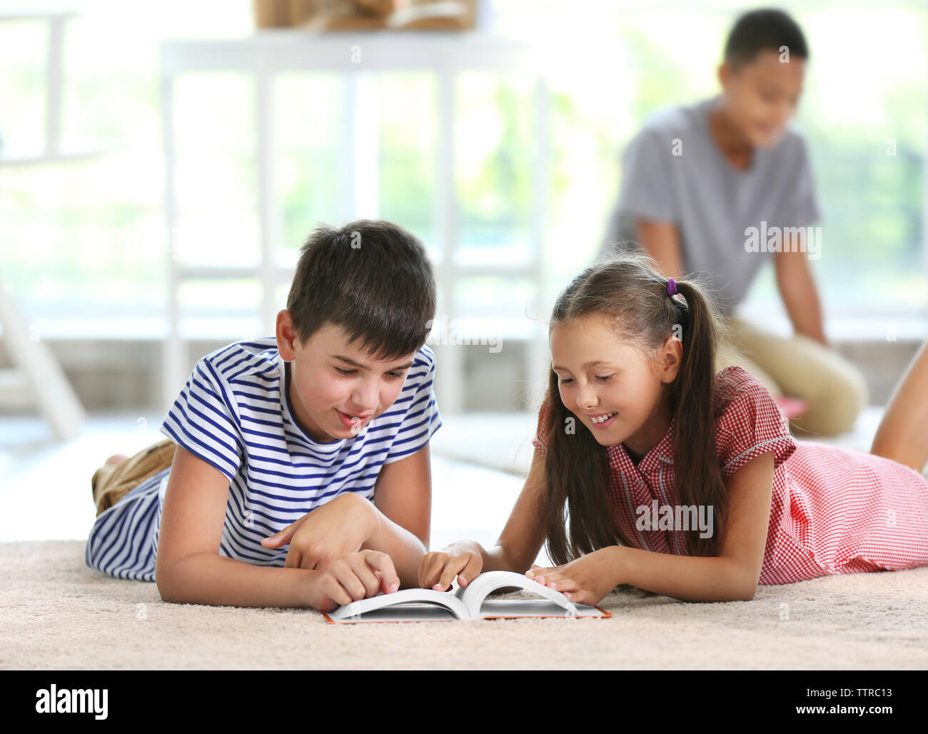 Cute kids reading book at home Stock Photo - Alamy