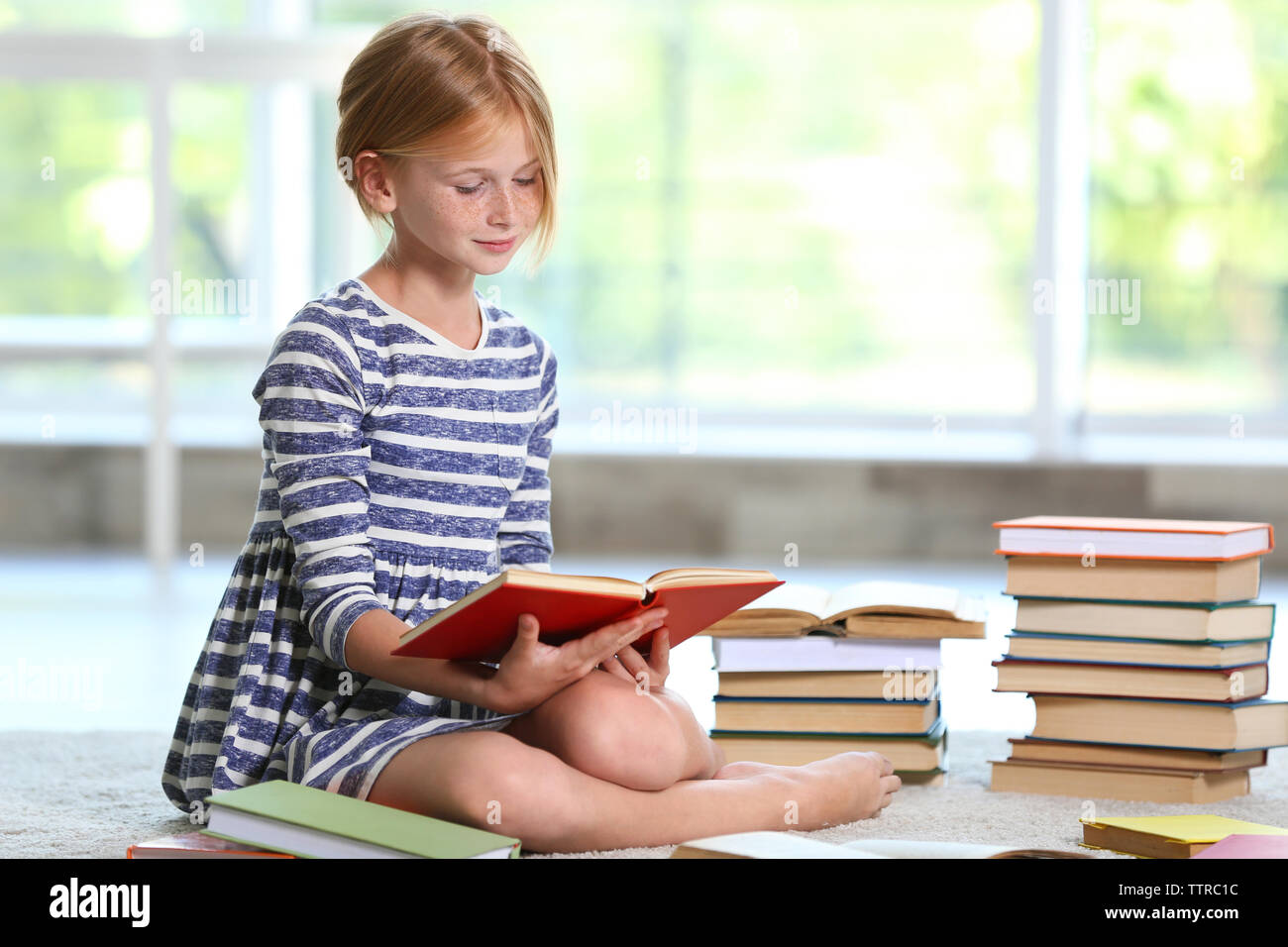 Cute girl reading book at home Stock Photo - Alamy