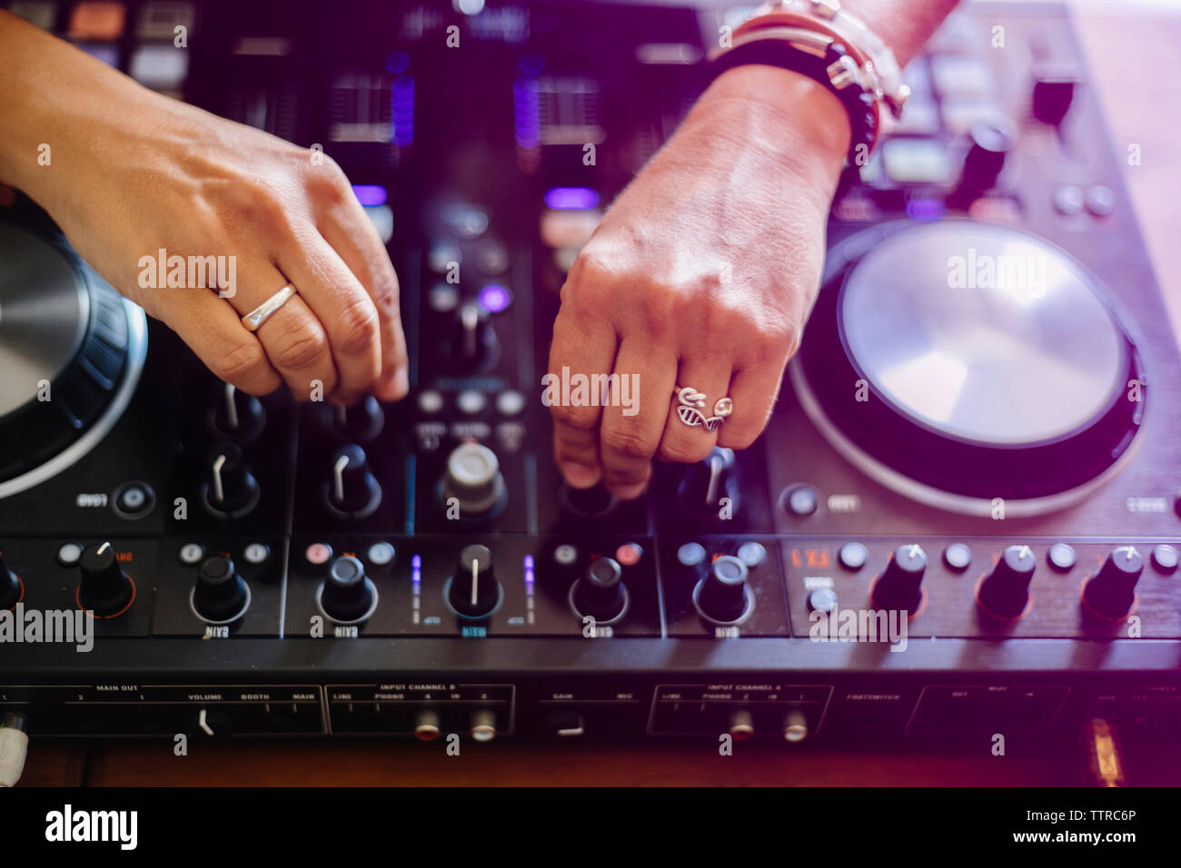 High angle cropped hands of female DJ mixing sound in recording studio ...