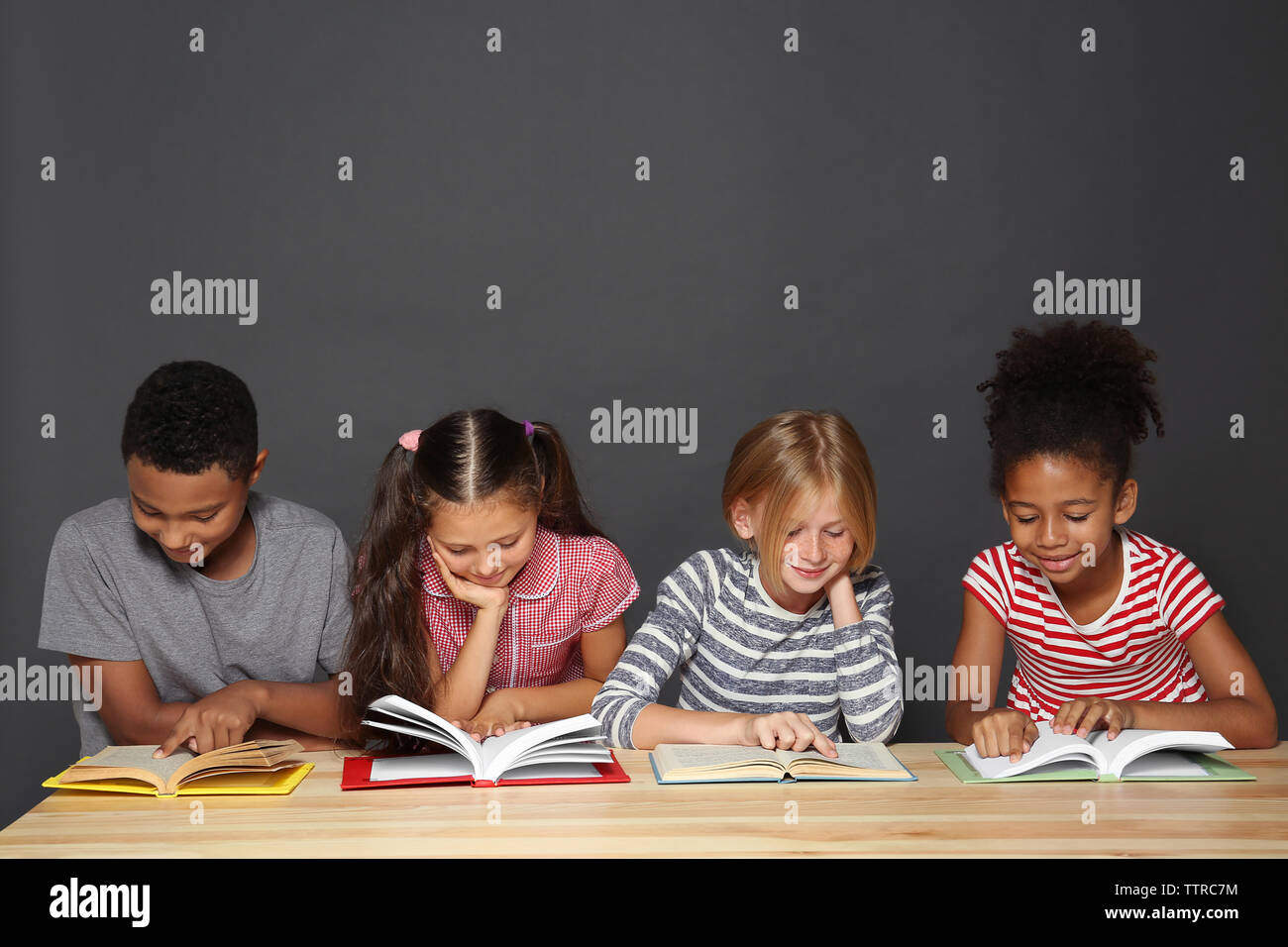 Cute kids reading books on grey background Stock Photo - Alamy