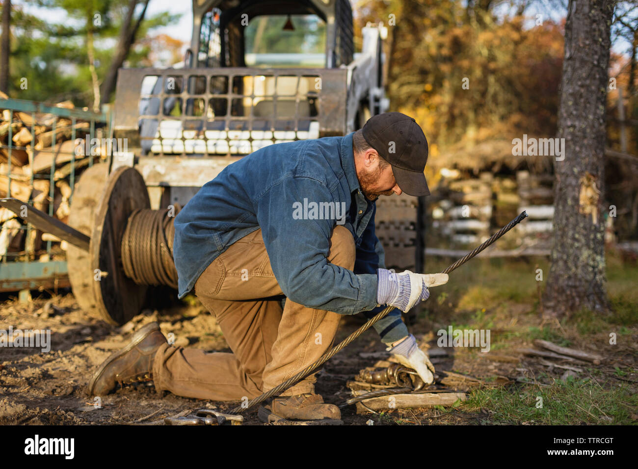 Man working on field by tractor Stock Photo - Alamy