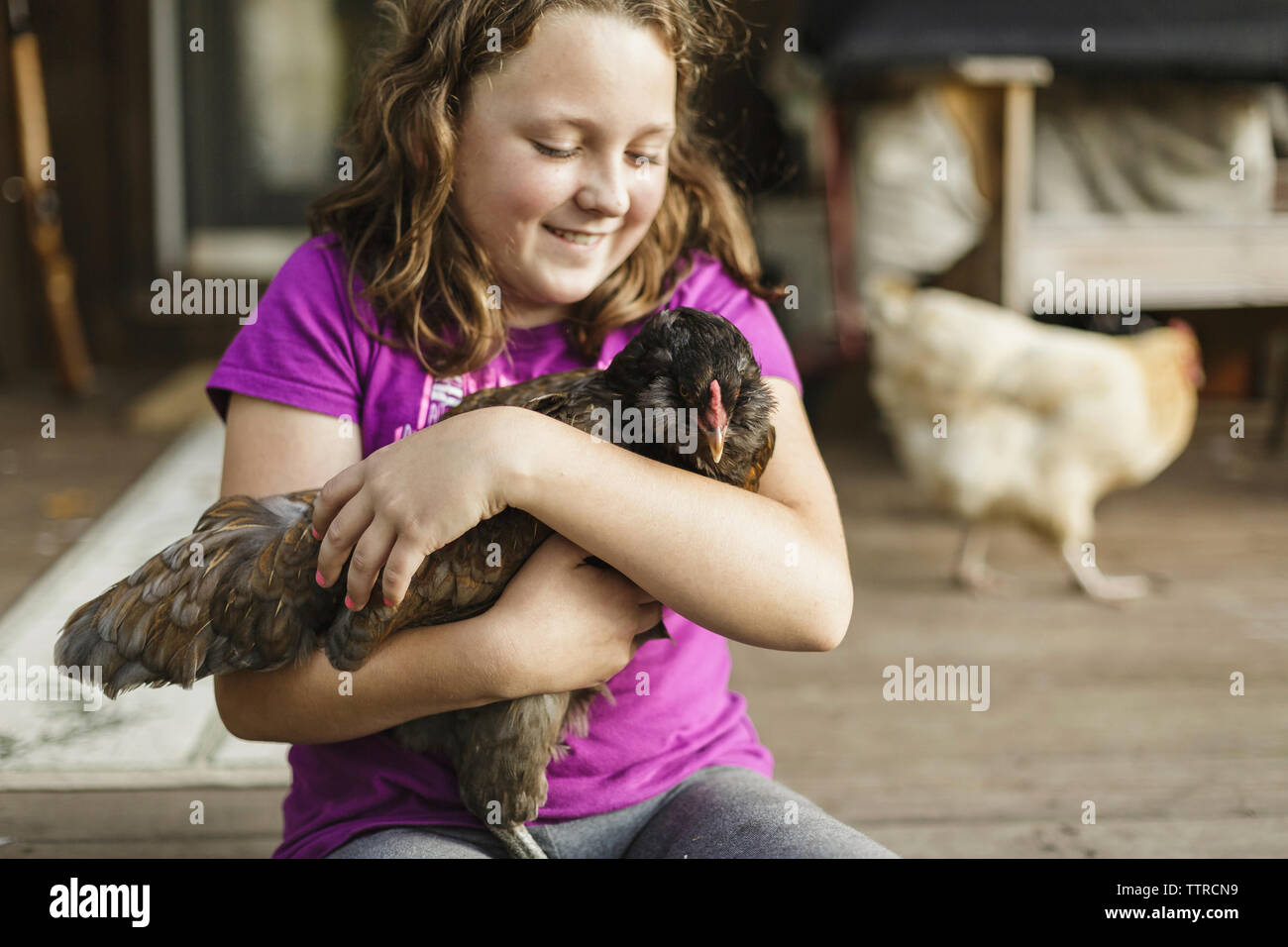 Happy girl carrying hen Stock Photo - Alamy