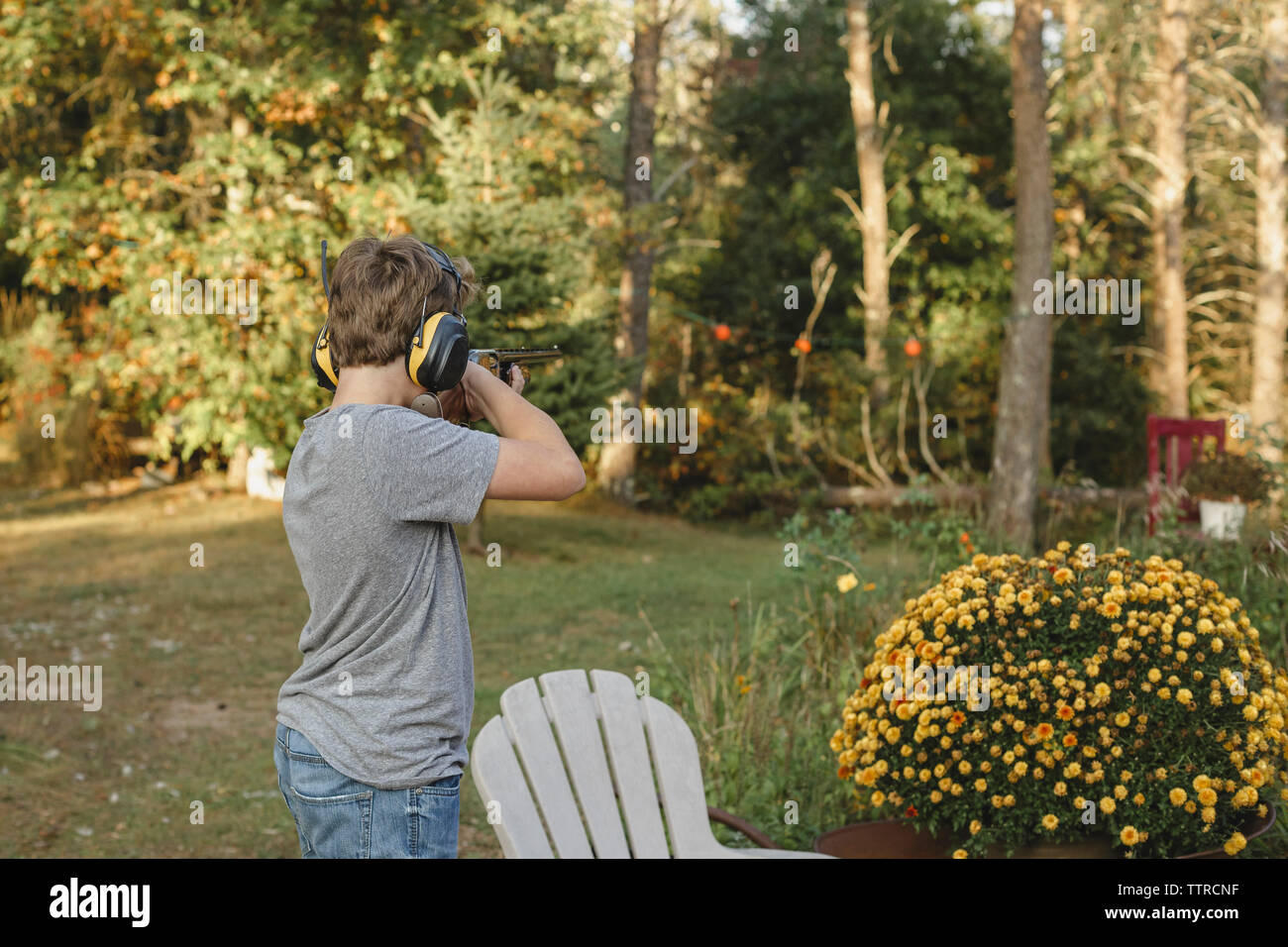 Side view of boy target shooting at backyard Stock Photo - Alamy