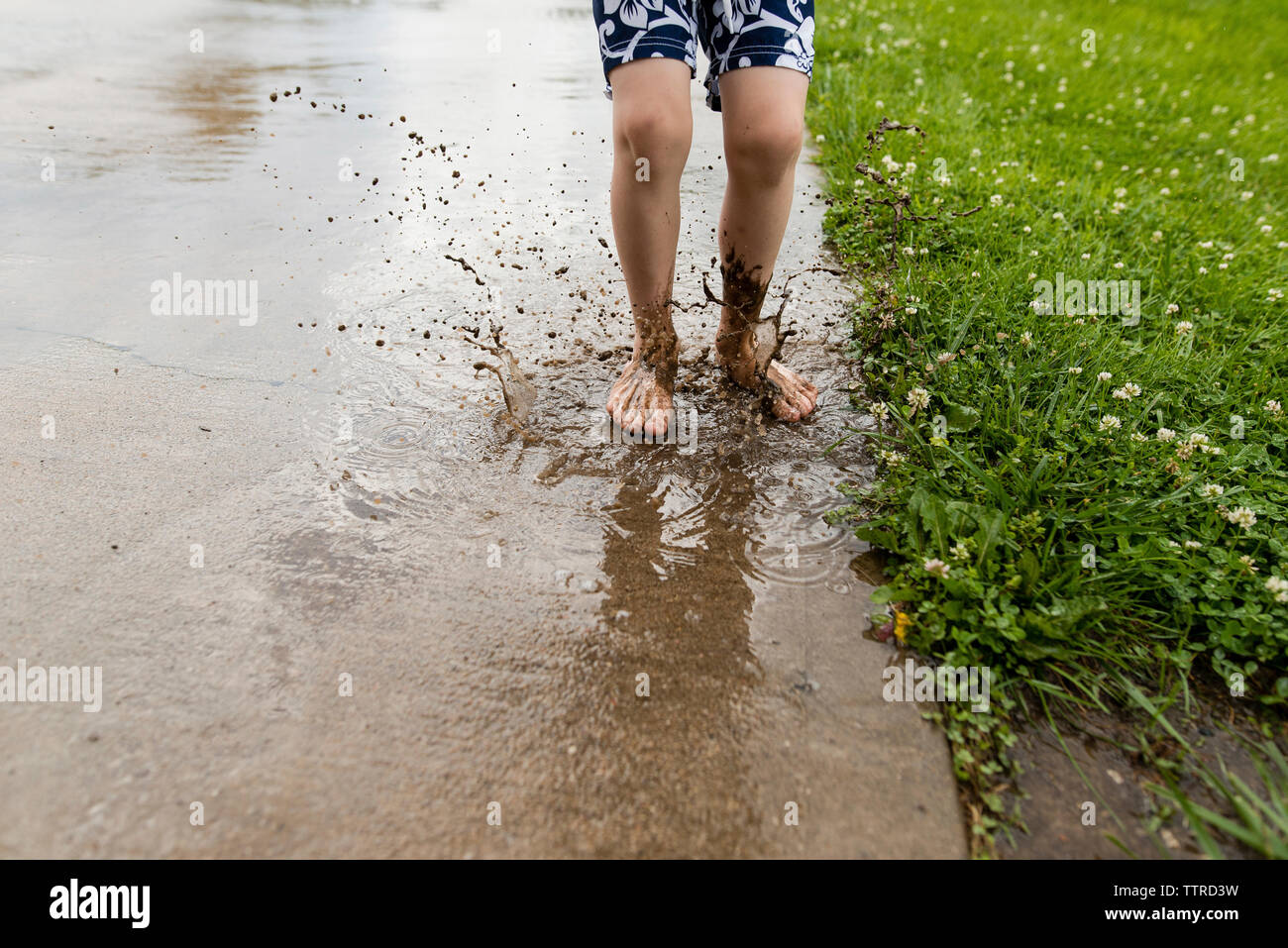Boy jumping in puddle hi-res stock photography and images - Alamy