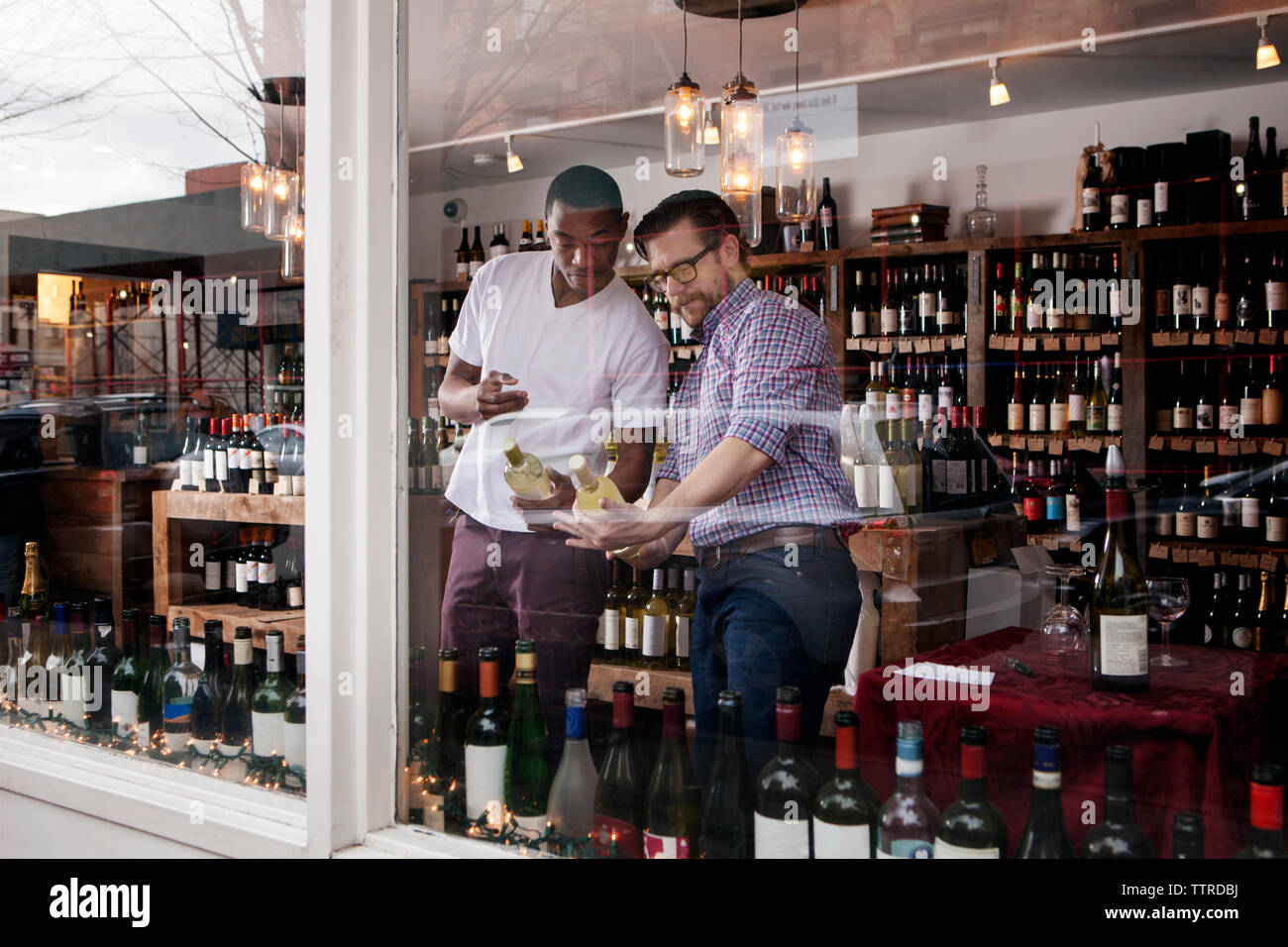Multi-ethnic colleagues discussing in wine shop Stock Photo - Alamy Multi-ethnic colleagues discussing in wine shop Stock Photo - Alamy