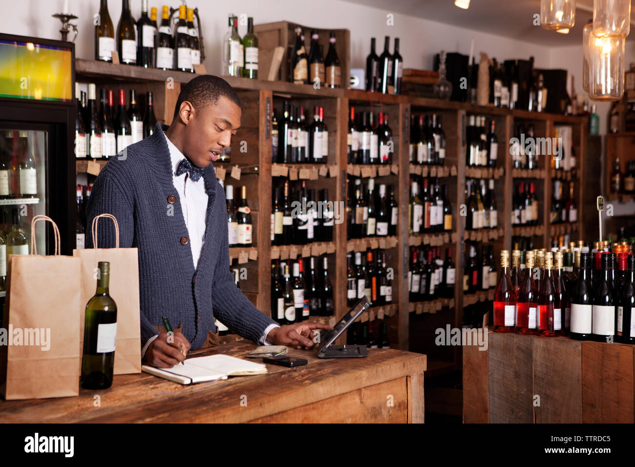 Male small business owner working at checkout counter in workshop Stock ...