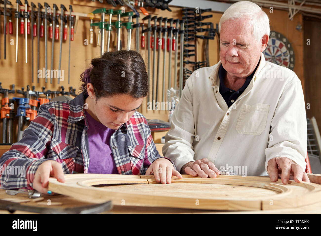 Carpenter teaching girl in workshop Stock Photo - Alamy