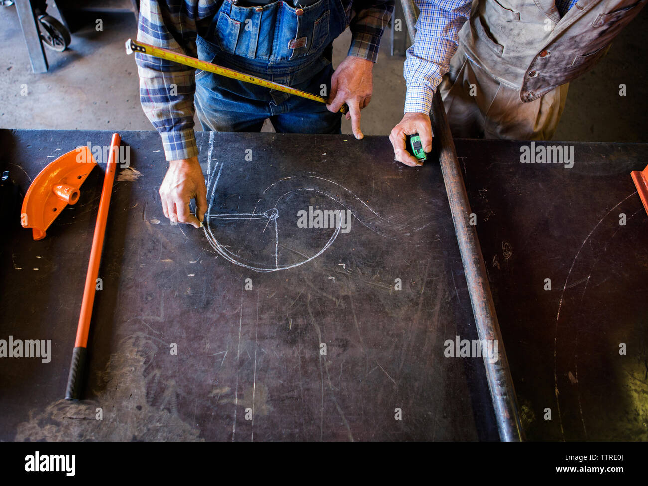 Craftsmen planning and drawing on workbench at factory Stock Photo - Alamy