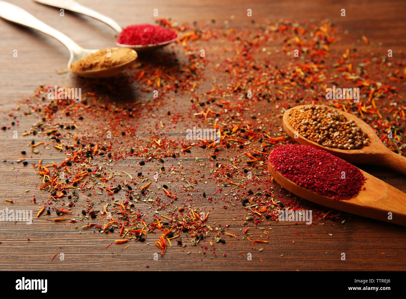 Spices in spoons on a wooden background Stock Photo - Alamy