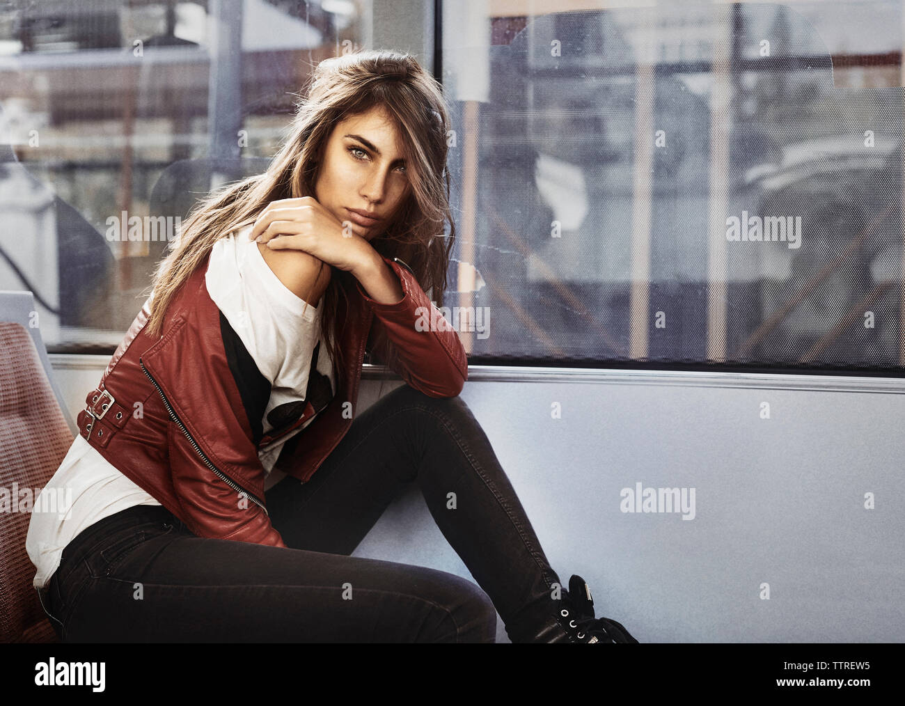 Side view portrait of confident young woman wearing leather jacket ...