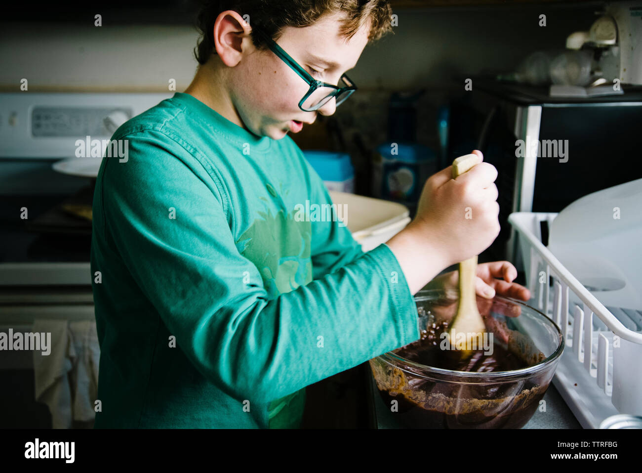 Boy mixing chocolate in kitchen hi-res stock photography and images - Alamy