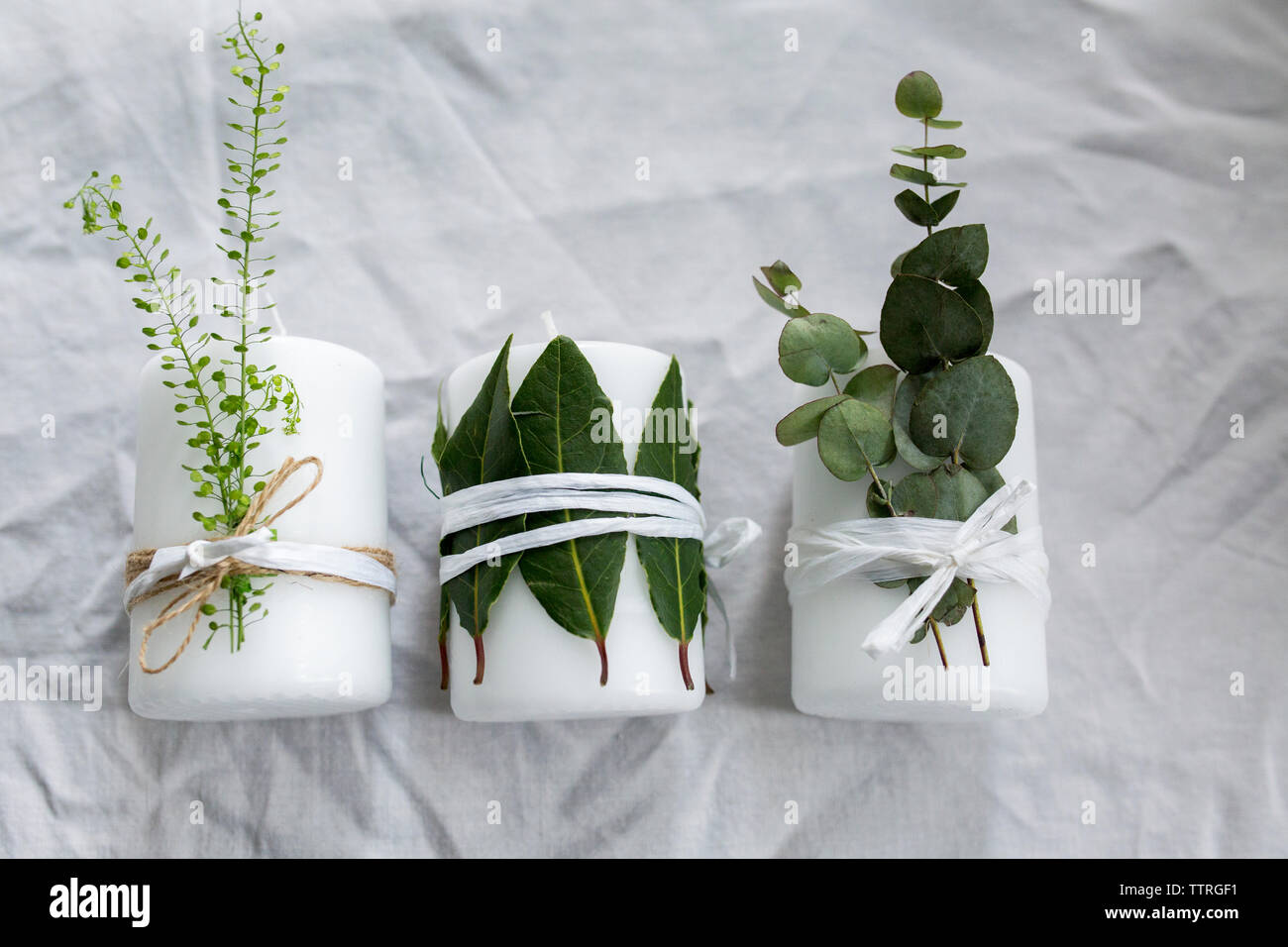 Overhead view of candles tied up with leaves on table Stock Photo - Alamy