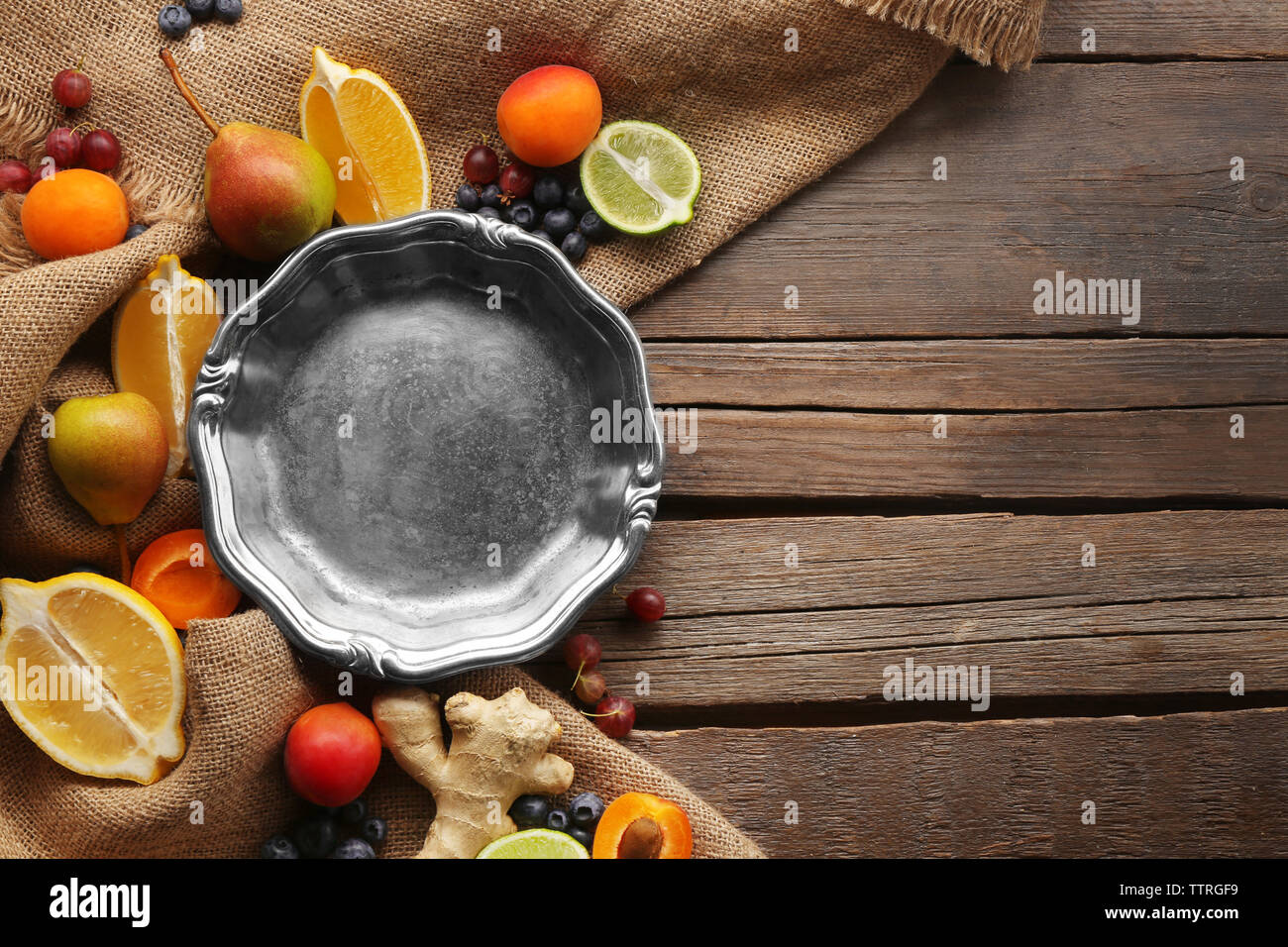 Different fruits with plate on table Stock Photo - Alamy