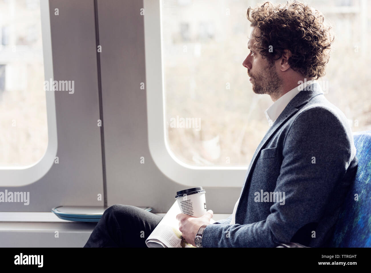Side view of businessman looking through train window Stock Photo - Alamy
