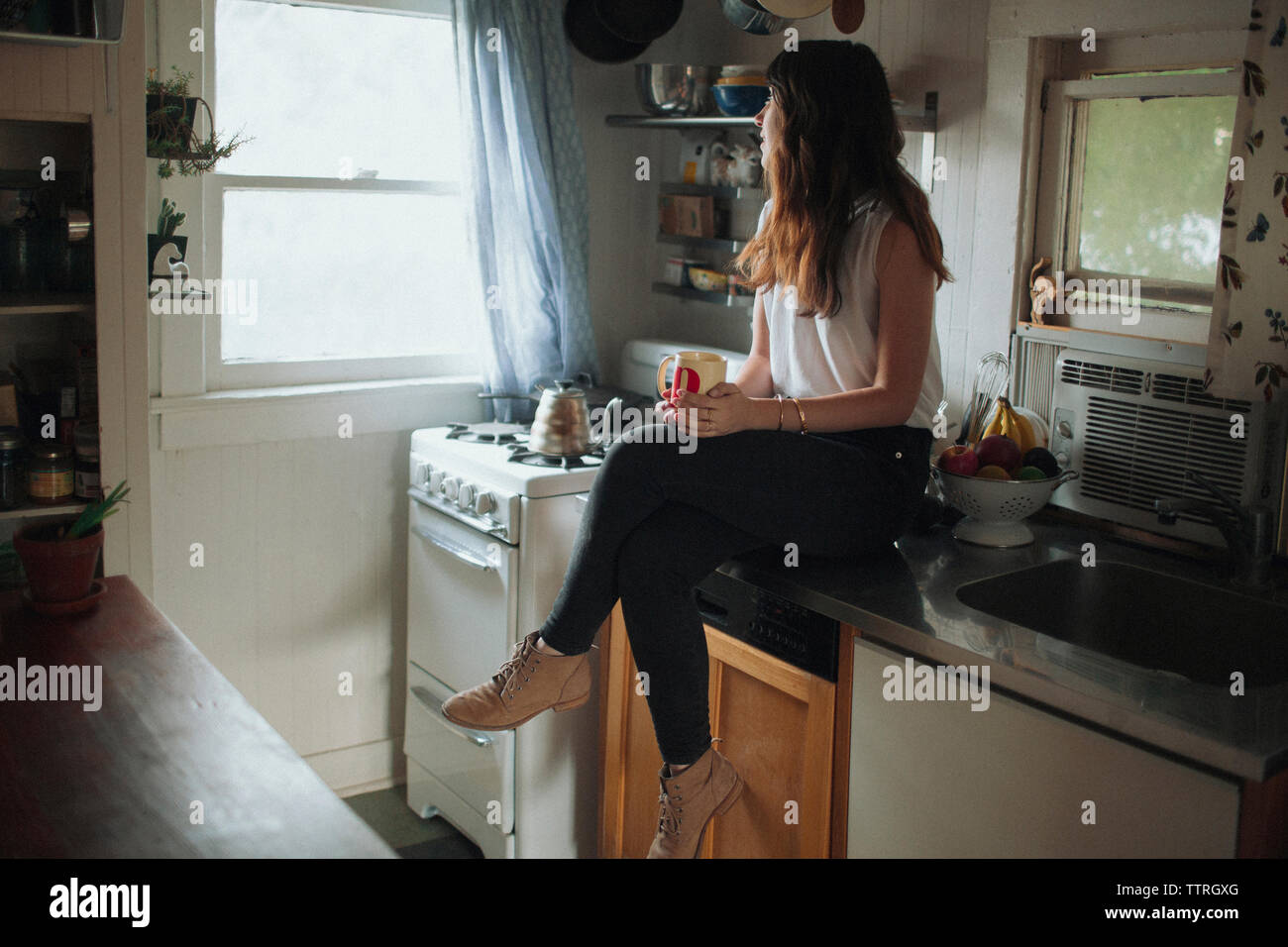 Woman sitting on counter hi-res stock photography and images - Alamy