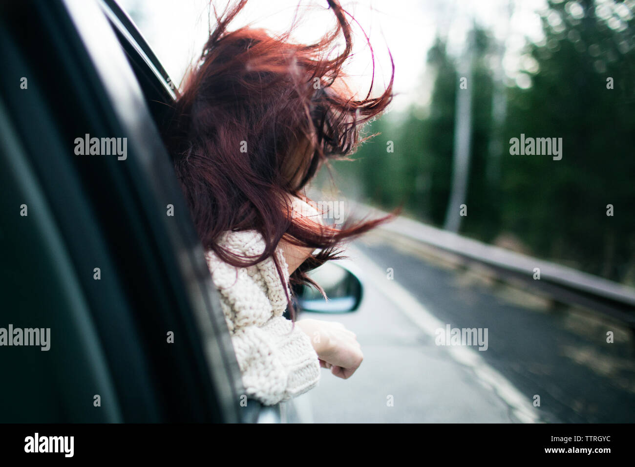 Teenager enjoying wind while peeking through car window Stock Photo - Alamy