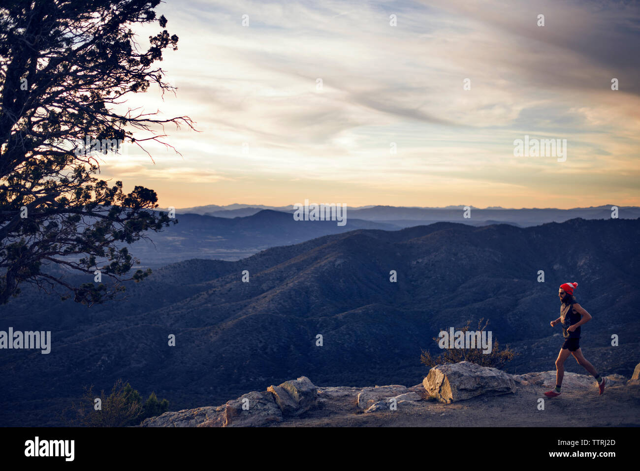 Man running on rock with mountains in background Stock Photo - Alamy