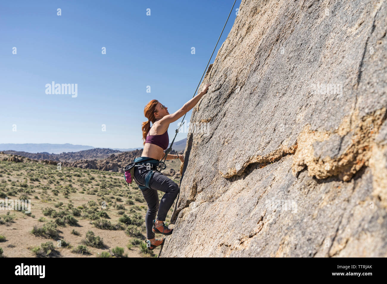Side view of female hiker climbing on mountain Stock Photo - Alamy